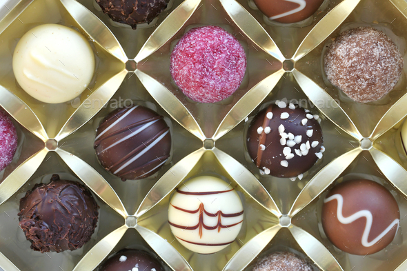 Assorted elegant chocolates in a gold container - full frame background ...