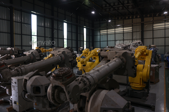 Automated robotic arms lined up in a high-tech manufacturing plant ...