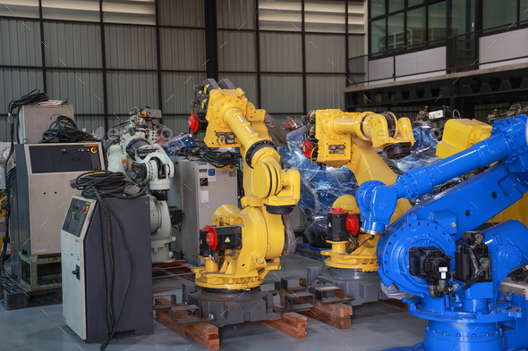 Automated robotic arms lined up in a high-tech manufacturing plant ...