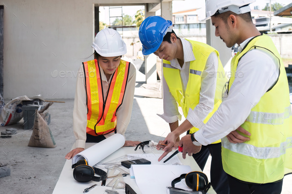 Civil engineering team meets to plan work on construction project in ...