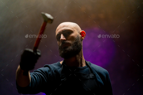 bald brazen robber with a beard holding a hammer during robbery attack ...