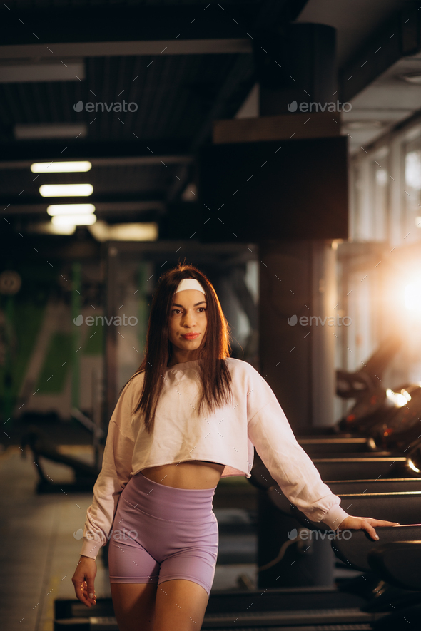 Side view of beautiful muscular woman running on treadmill. Stock Photo ...