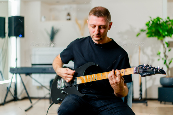 rock performer with electric guitar in recording studio playing musical ...