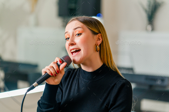 young girl sings in a vocal lesson with a microphone in her hands ...