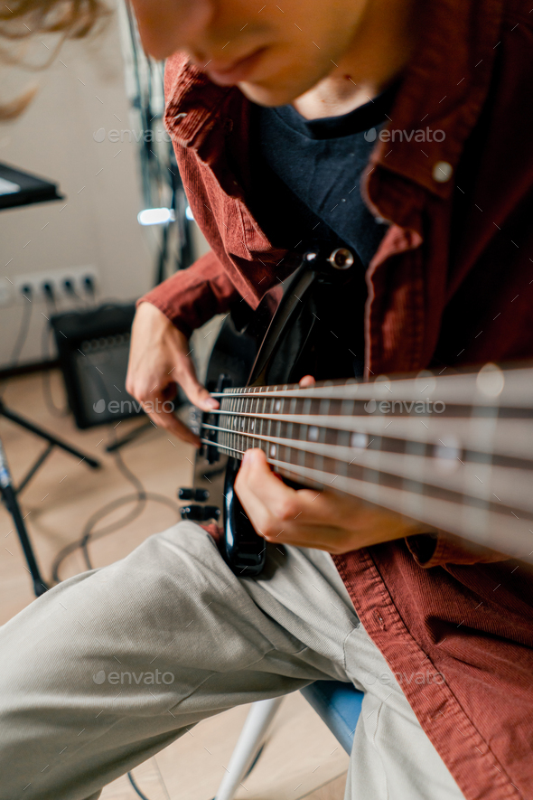 musician with electric guitar in recording studio plays musical ...