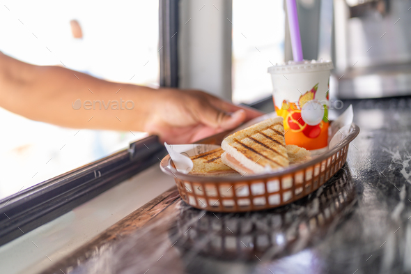 Man grabbing a sandwich and beverage in a food truck Stock Photo by GSR ...