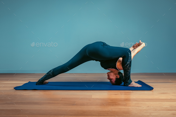 Young asian woman in the Bakasana Crane yoga pose. Attractive female ...
