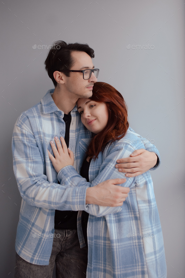 sincere hugs of lovers indoors at home on grey wall background ...