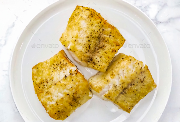 Fried fish fillet steak with salt pepper on plate. Homemade cooking ...