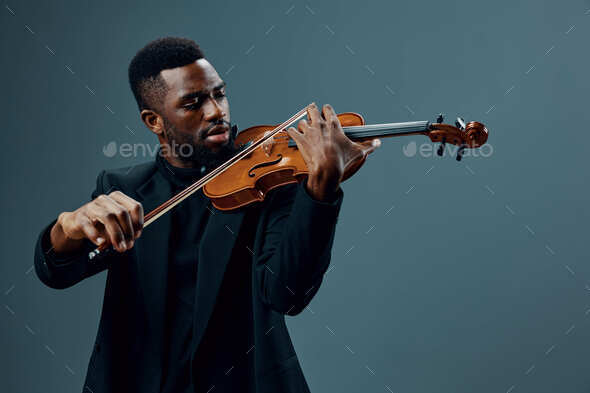 African American man in black suit playing violin, creating soulful ...