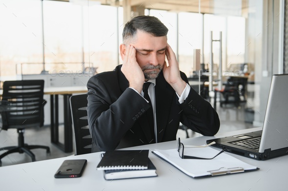 Tired stressed office worker sitting at desk and thinking Stock Photo ...