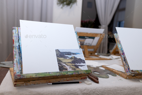 A clean white canvas and a sample drawing on an easel. Drawing master ...