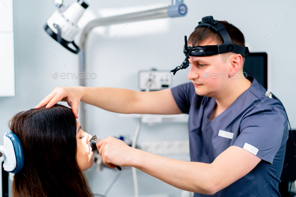 the ENT doctor examines the patient in the office of clinic checks oral ...