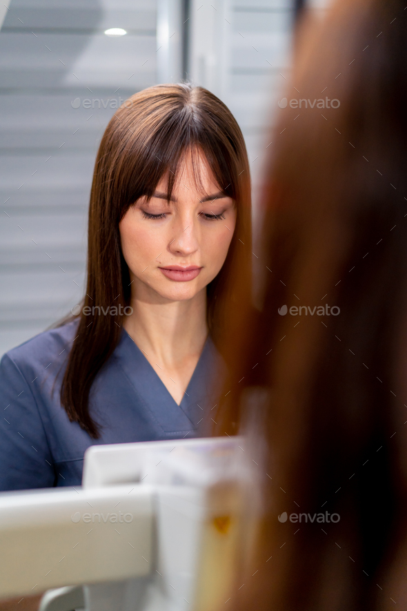 female doctor makes a 3D scan of the nose and oral cavity of a patient ...