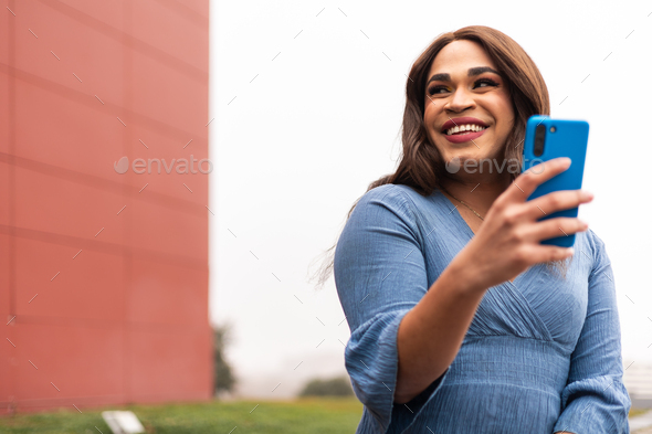 Close-up portrait of trans woman using cellphone and laughing Stock ...