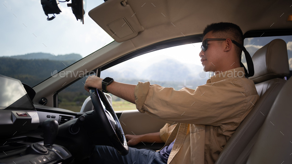 Handsome Asian male solo traveler enjoying his journey, driving car on ...