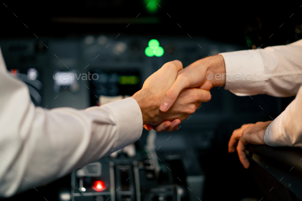 pilots in the cockpit of plane greet each other and shake hands before ...