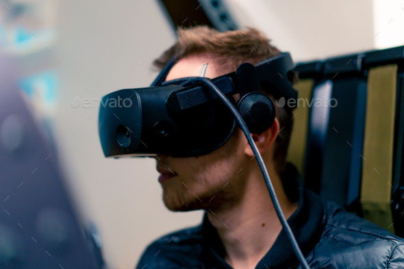 boy sitting in flight simulator military plane wearing virtual reality ...