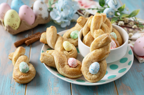 Easter rabbit-shaped buns puff pastry with cinnamon on a wooden blue ...