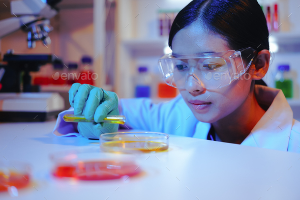 Asian female scientist passionately conducts experiments in a laboratory Stock Photo by chuemoonrin