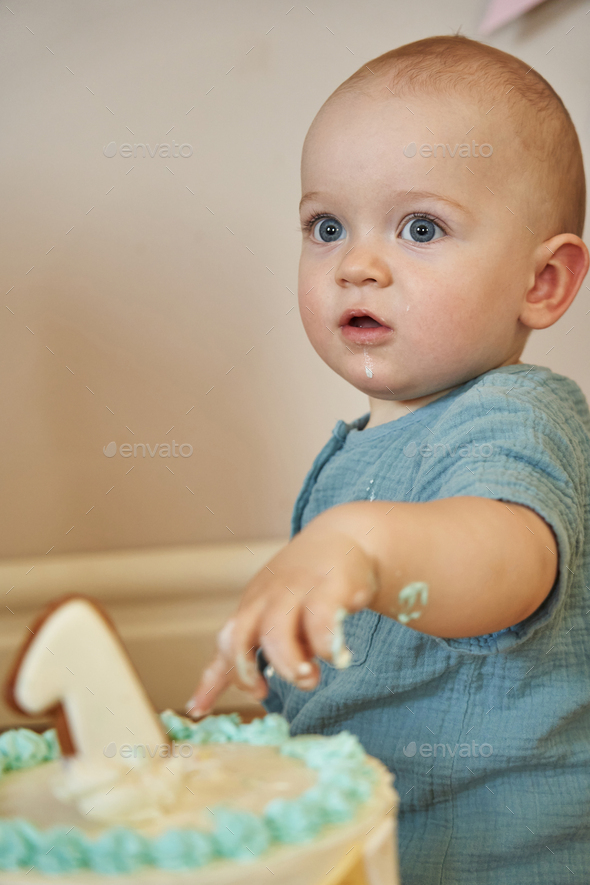 The birthday boy relishes every bite of his cake as he turns one. Stock ...