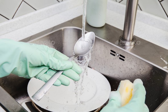 Hand Washing Utensils spoon in a Stainless Steel kitchen Sink Stock ...