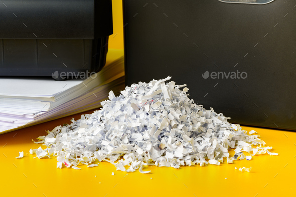 Office paper shredder on yellow studio background Stock Photo by ...