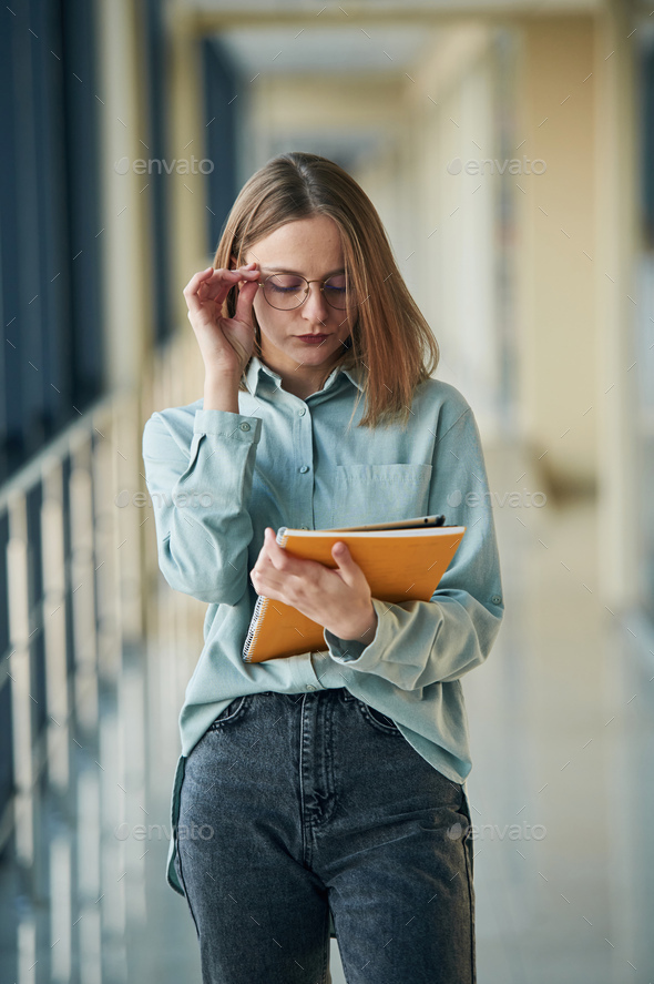 Posing, holding yellow notepad. Young woman in airport hall Stock Photo ...