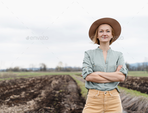 Female farmer standing proudly in agricultural field. Smiling ...