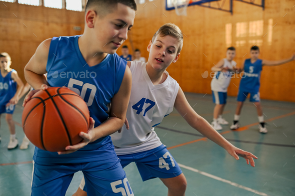 Junior basketball player practicing basketball on court during training ...