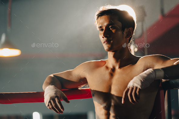 Asian man boxer having strength body working out exercise in gym ...