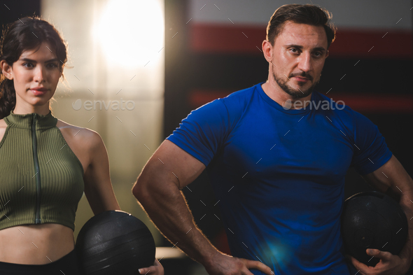 Personal trainer coach helping young woman exercising in the sport gym ...