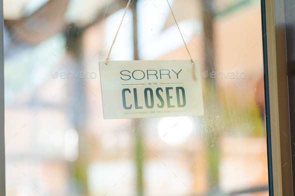 Woman staff turning close sign board on glass door in coffee shop and ...