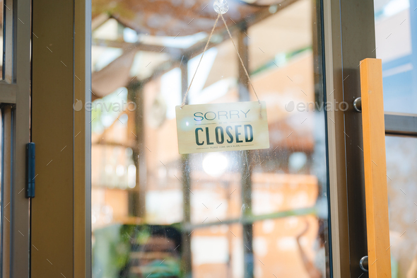Woman staff turning close sign board on glass door in coffee shop and ...