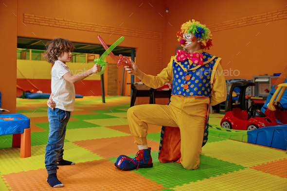 Happy boy and clown playing toy sword made from balloon Stock Photo by ...