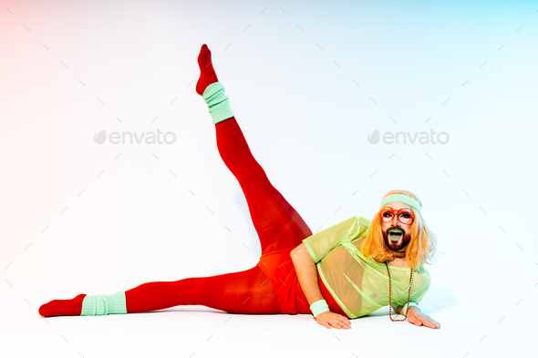 Vibrant Drag Queen in 80s Sportswear Practicing Stretching Exercises in ...