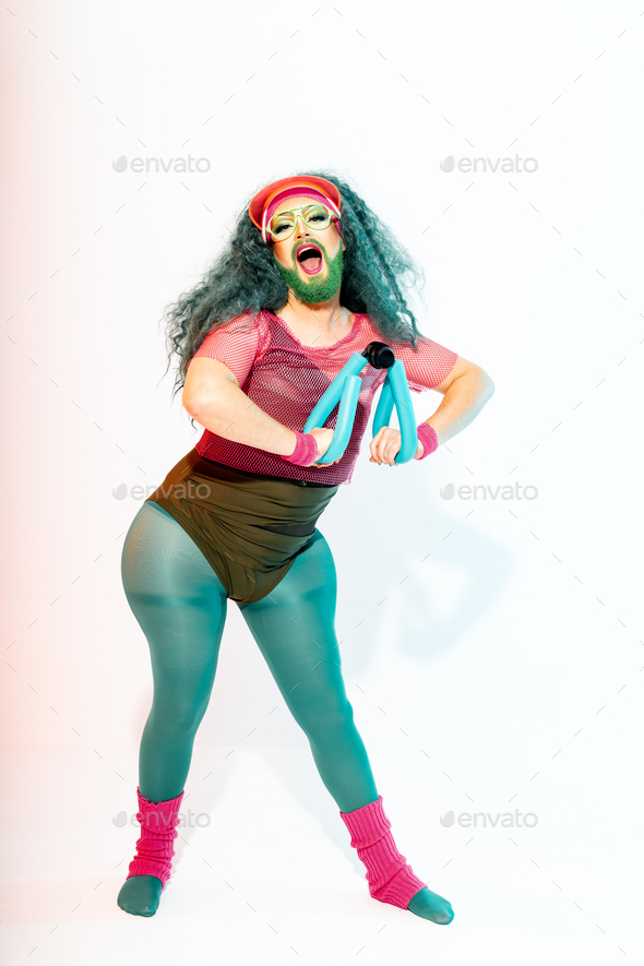 Excited man in drag queen 80s retro costumes exercicing in studio with ...