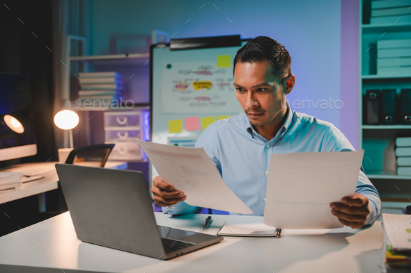 Male employee working late and stressed with failed work Young asian ...