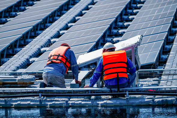 Local worker working at floating solar panels platform on the water of ...