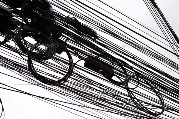 Many electrical cable are tangled on an electric pole. Stock Photo by bowonpats