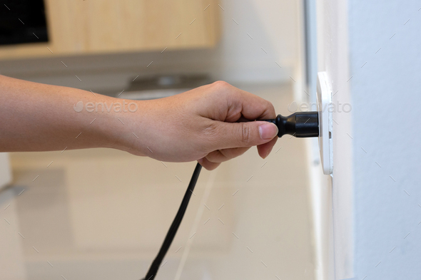 Hand insert a plug into socket. Stock Photo by bowonpats | PhotoDune