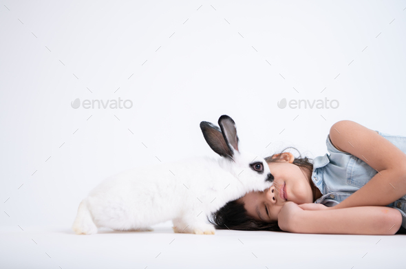 Smiling little girl and with their beloved fluffy rabbit, showcasing ...