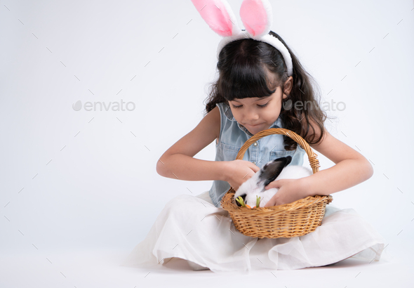Smiling little girl and with their beloved fluffy rabbit, showcasing ...