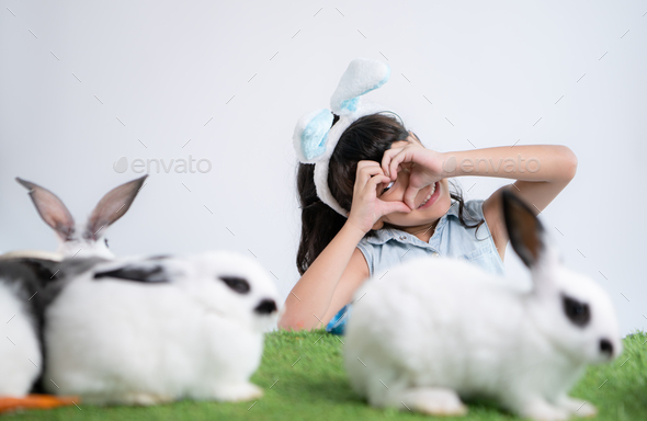 Smiling little girl and with their beloved fluffy rabbit, showcasing ...
