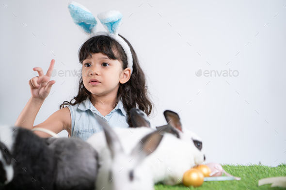 Smiling little girl and with their beloved fluffy rabbit, showcasing ...