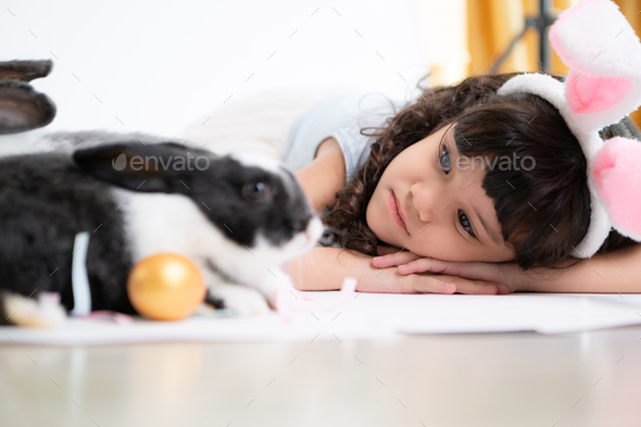 Smiling little girl and with their beloved fluffy rabbit, showcasing ...