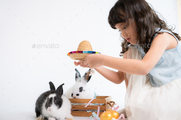 Smiling little girl and with their beloved fluffy rabbit, showcasing ...