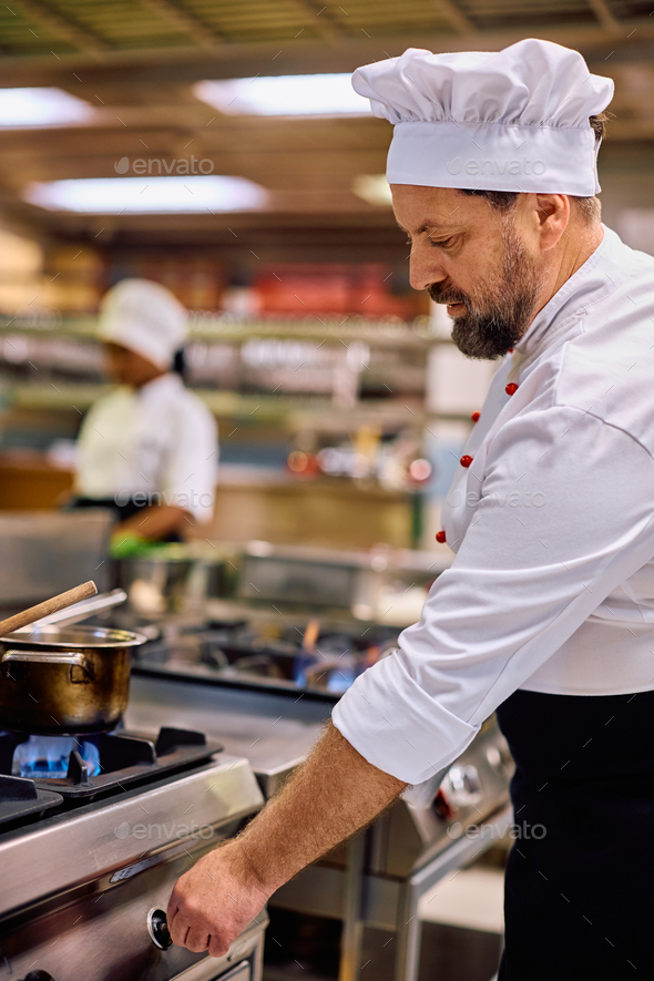 Professional chef cooking in the kitchen in a restaurant. Stock Photo ...