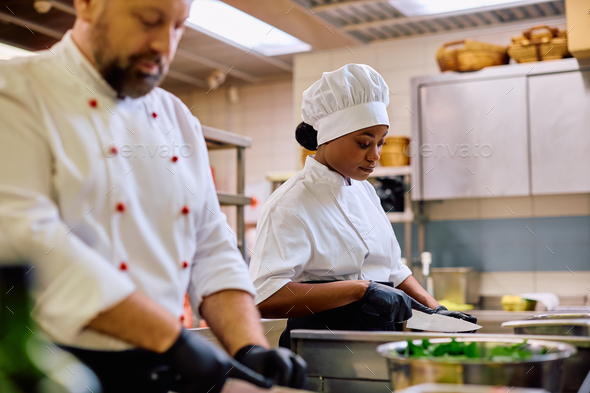 Black female chef working int he kitchen in a restaurant. Stock Photo ...