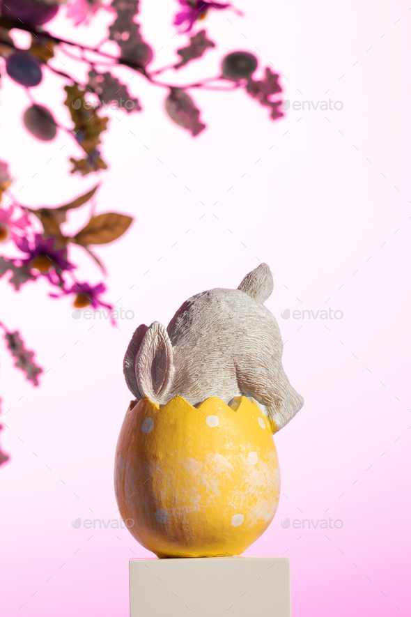Inside the bright yellow Easter egg, a plush rabbit nestles comfortably ...